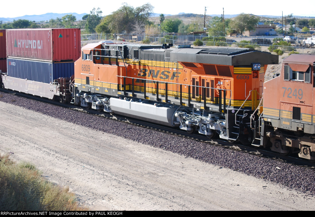 BNSF 6809 rolls eastward behind BNSF 7249 as they slow down for the BNSF Barstow yard and a ...